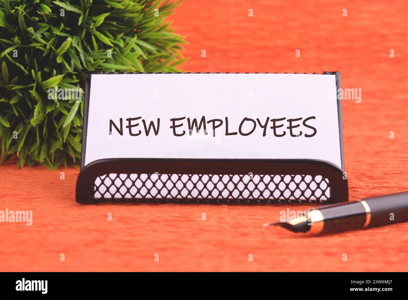 NEW EMPLOYEES word written on a white business card and a stand Stock ...