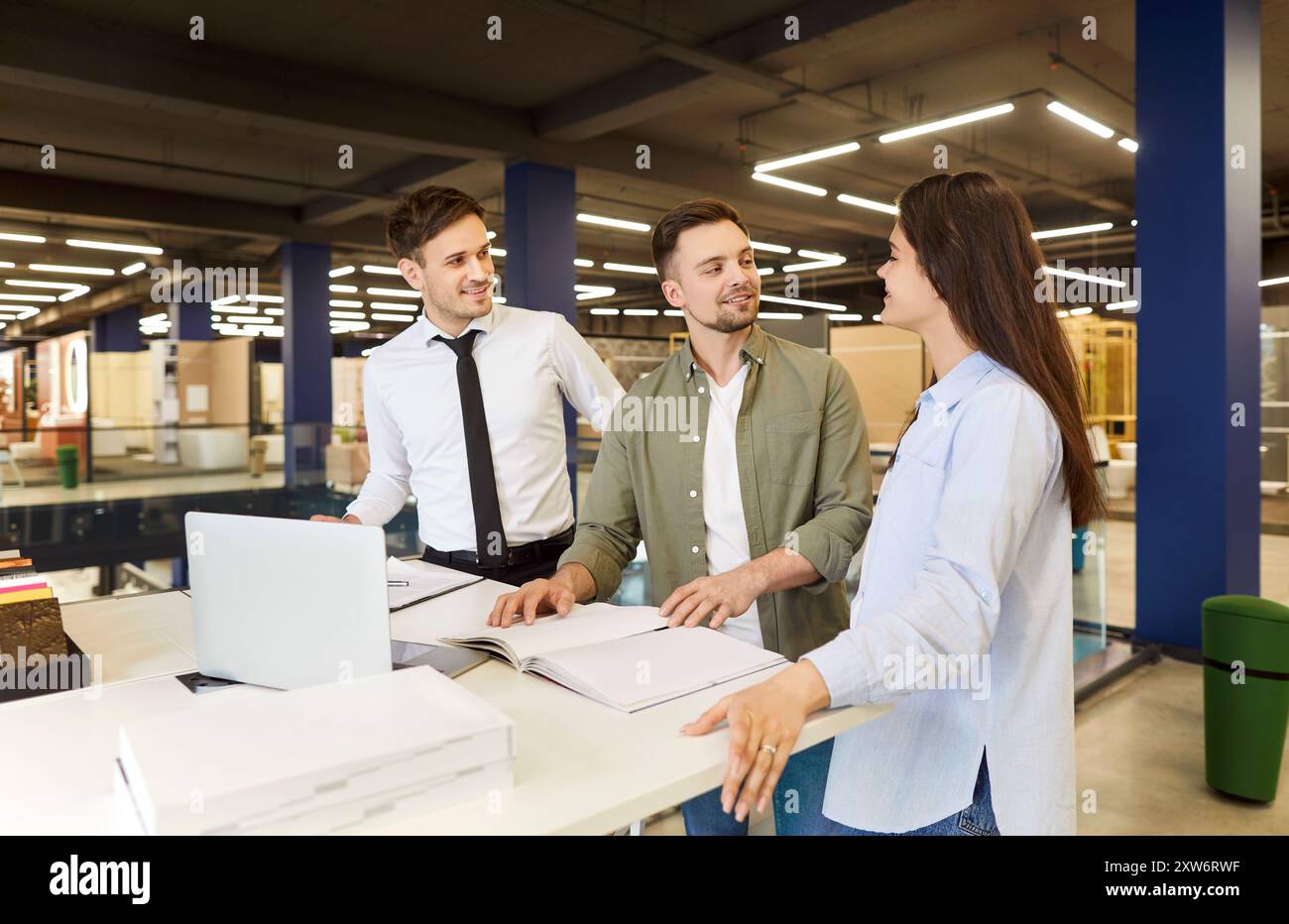 Salesman manager of construction market helping couple with choice ...