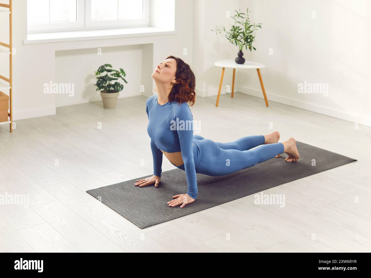 Attractive woman practicing yoga, stretching in Urdhva mukha shvanasana ...