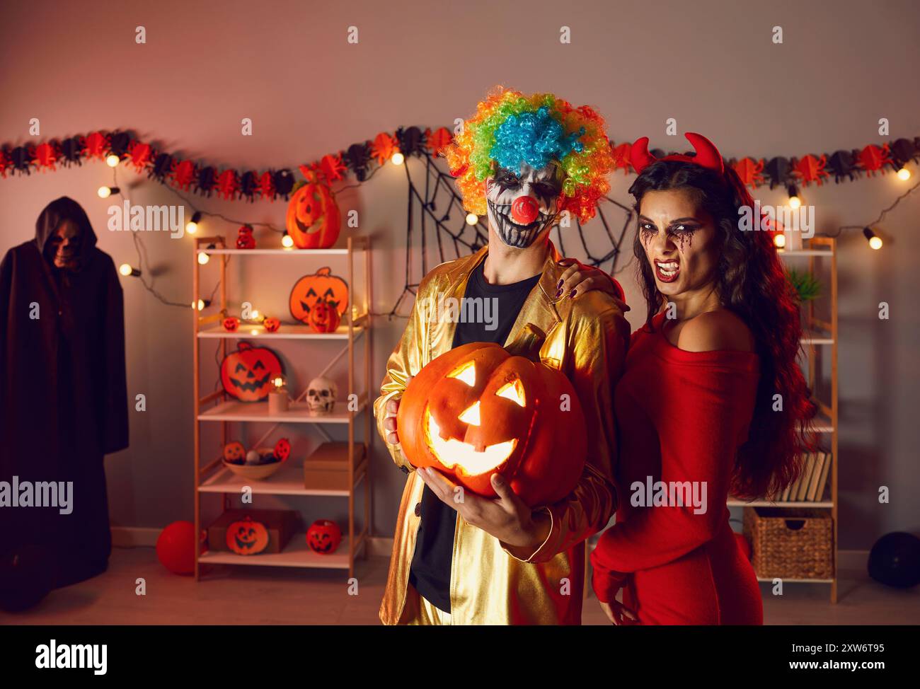 Portrait of two friends in spooky costumes of clown and devil at ...