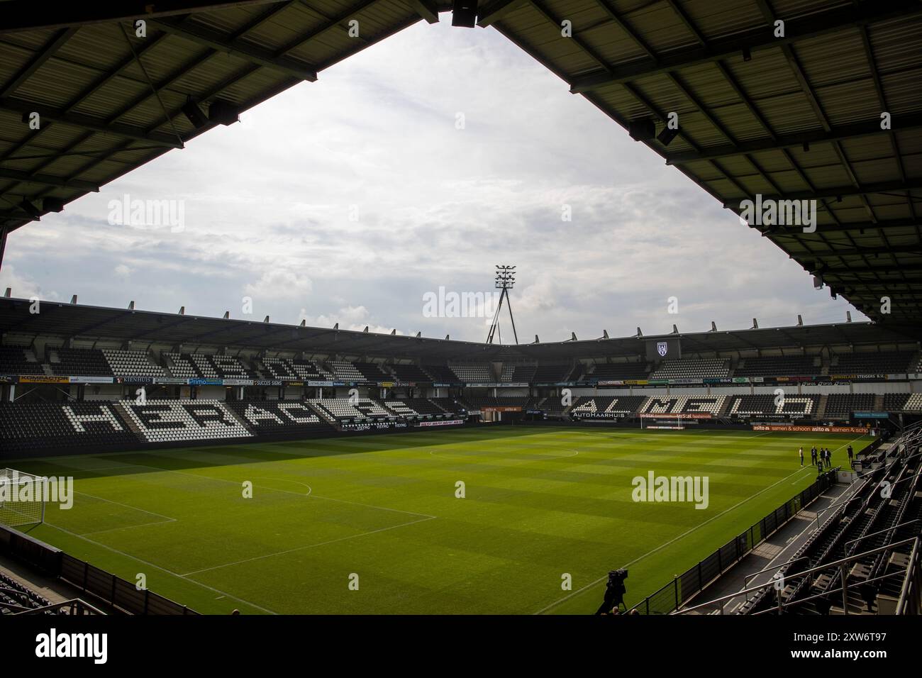 ALMELO - Interior of the stand with the grass pitch with name and logo ...