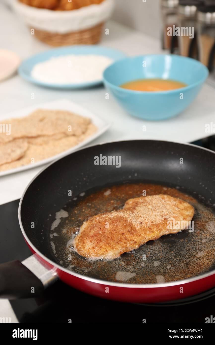 Cooking schnitzel in frying pan on stove, closeup Stock Photo - Alamy