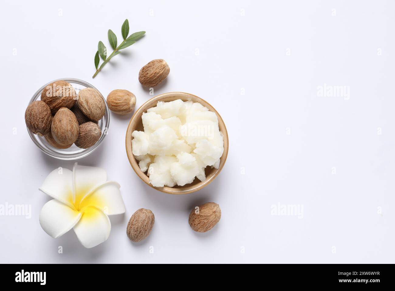Shea butter in bowl, flower and nuts on white background, flat lay ...