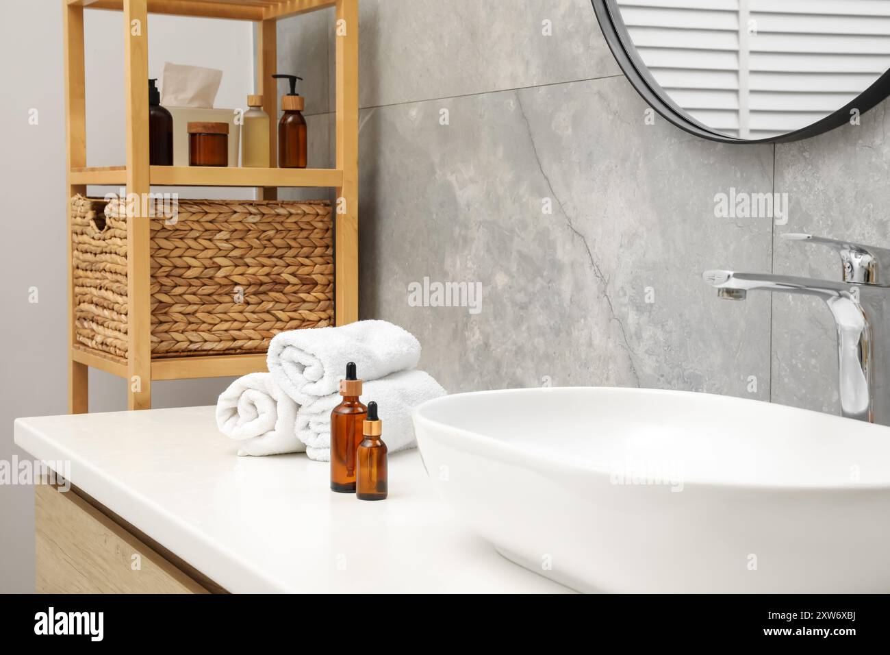 Vanity with sink, towels and shelving unit in bathroom Stock Photo - Alamy