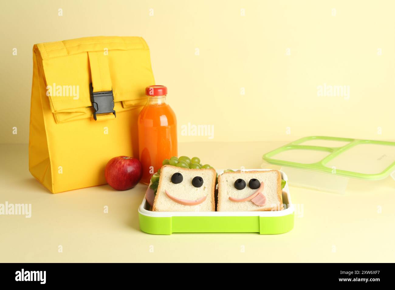 Bag, sandwiches with smiley faces in lunch box and bottle of juice a on ...
