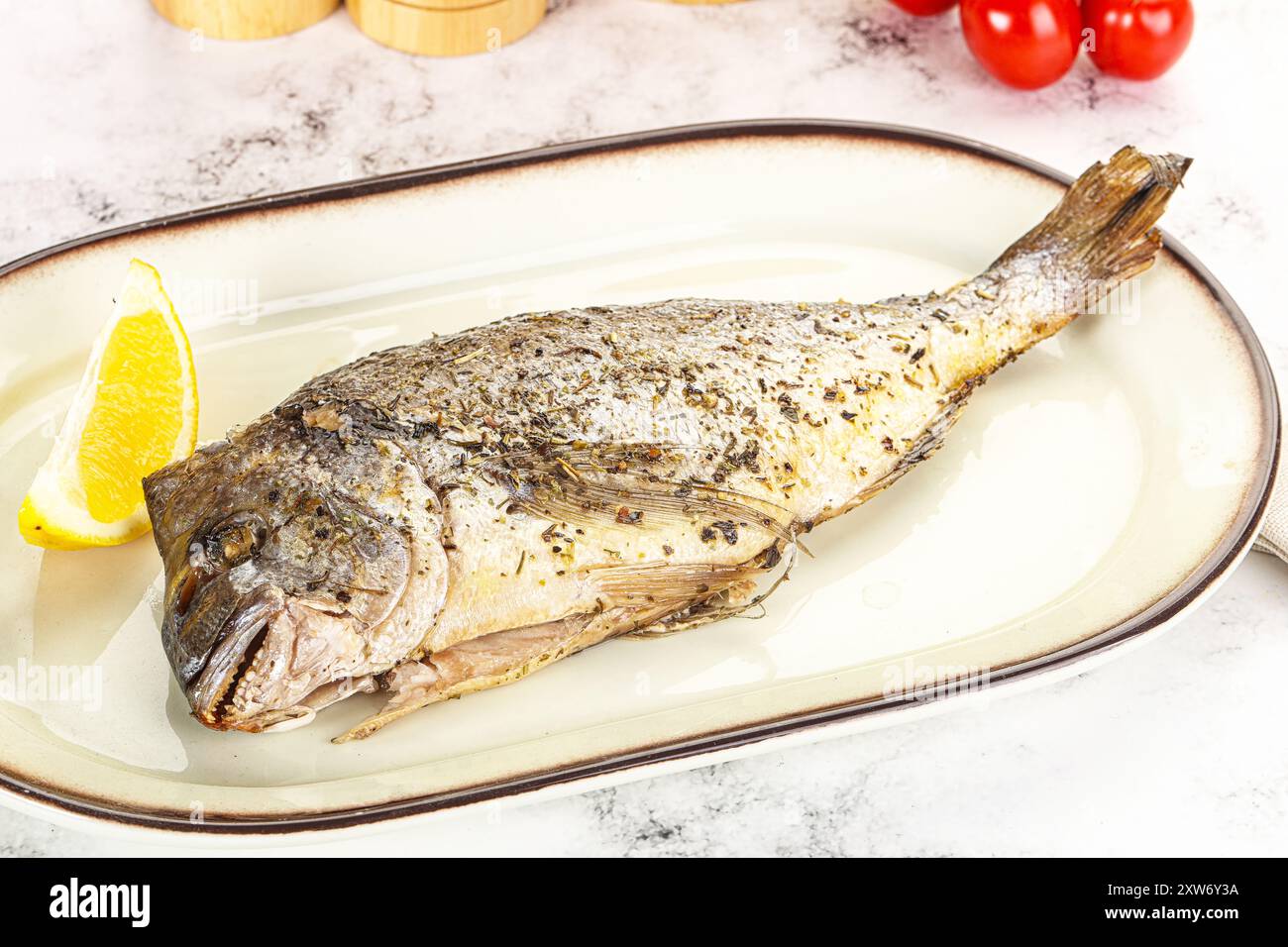 Baked Dorado fish served lemon slice Stock Photo - Alamy