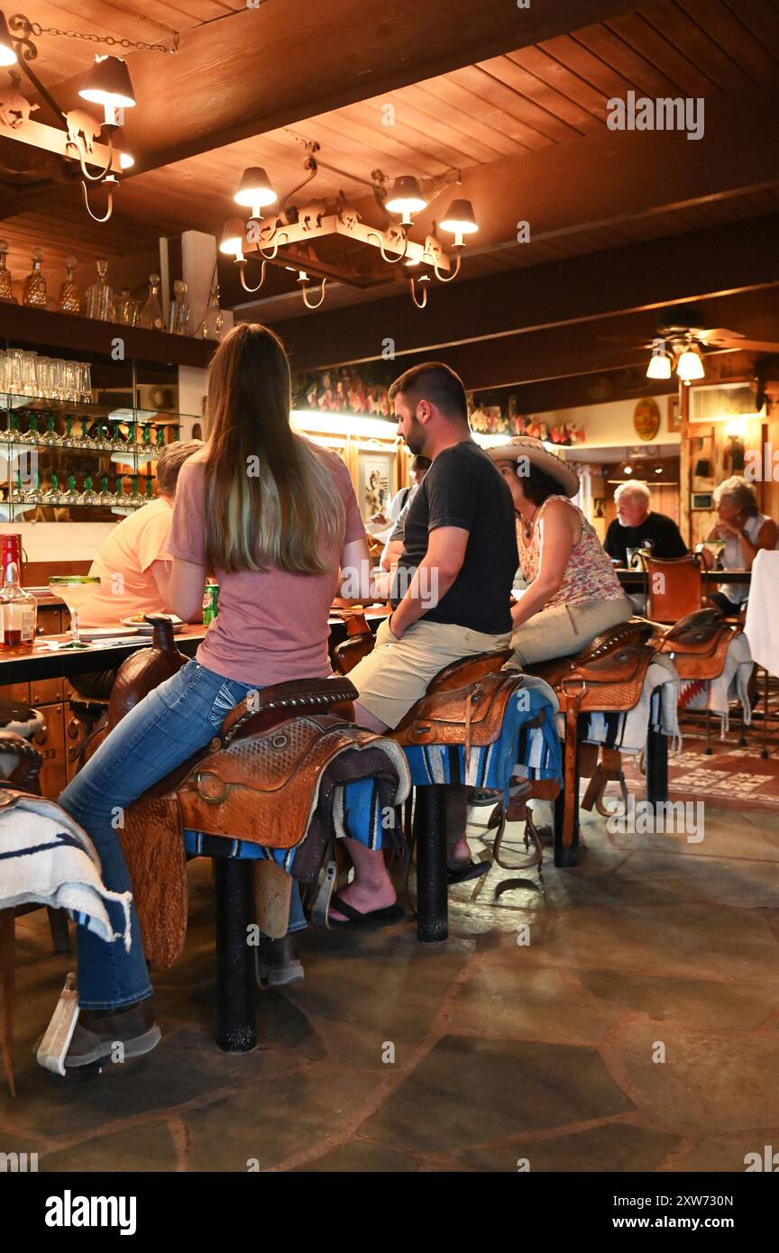 USA. ARIZONA. TUCSON. CUSTOMERS ON THE SADDLES OF THE WHITE STALLION ...