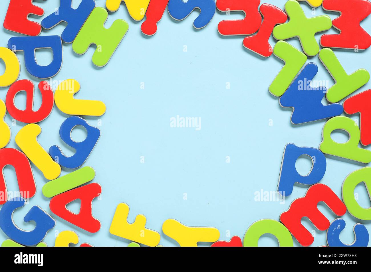 Learning alphabet. Frame made of magnetic letters on light blue ...