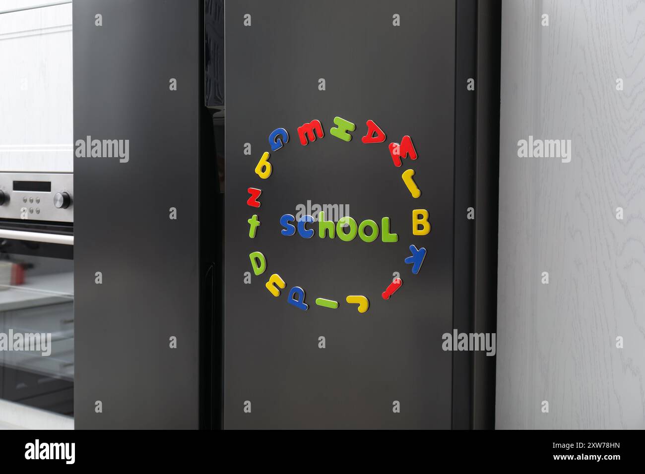 Word School and circle made of many bright magnetic letters on fridge ...