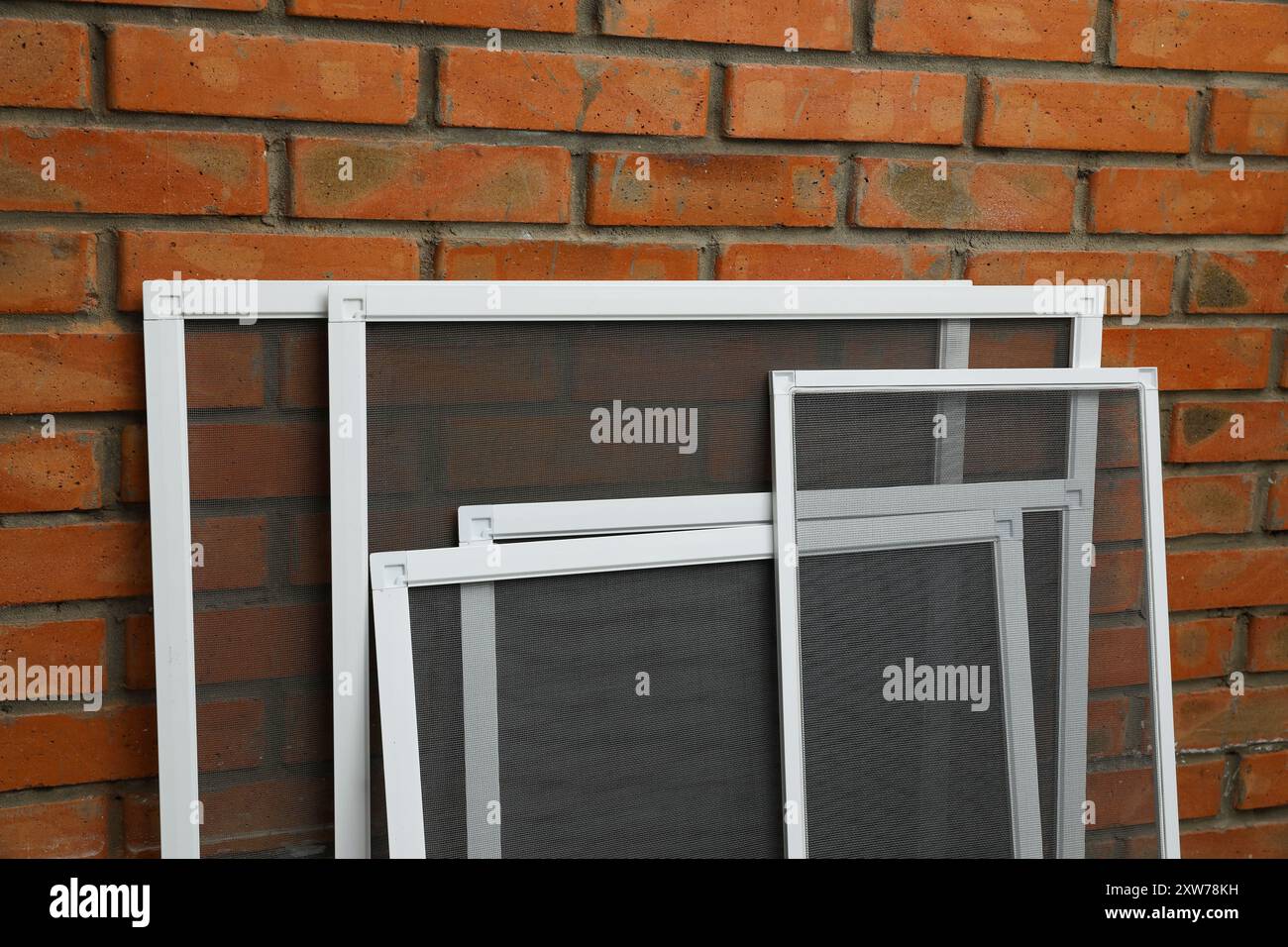 Set of window screens near brick wall Stock Photo - Alamy