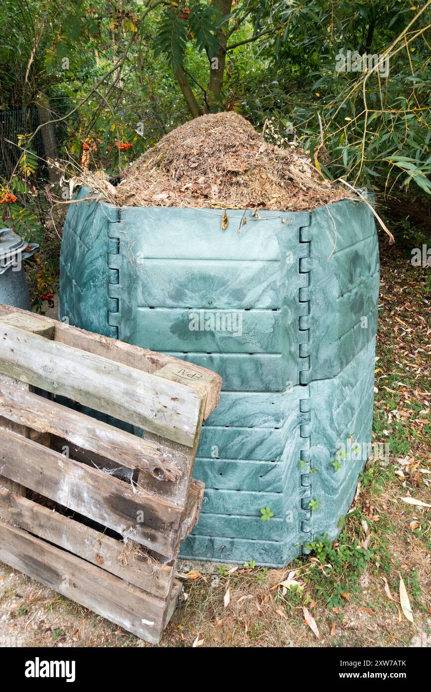 Plastic composter - bin in the garden, filled with cut grass Stock ...