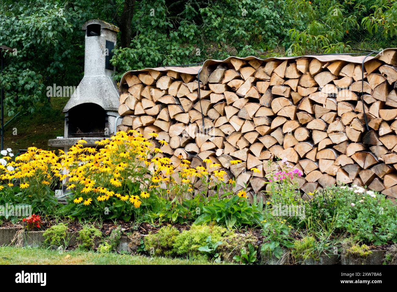 Garden fireplace and wood stored away for the winter stacked logs Stock ...