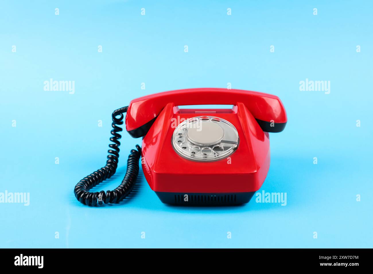 Red telephone with handset on light blue background Stock Photo - Alamy