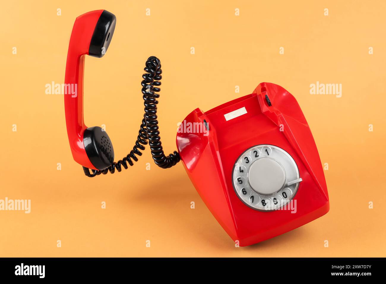 One red telephone with handset on pale orange background Stock Photo ...