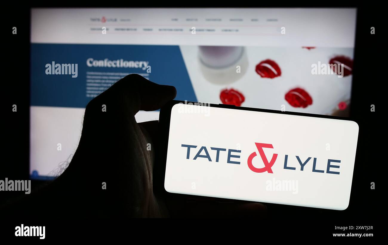 Person holding mobile phone with logo of British food processing ...