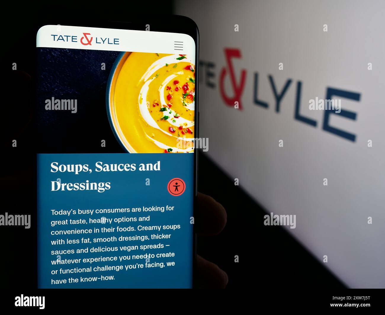 Person holding cellphone with webpage of British food processing ...