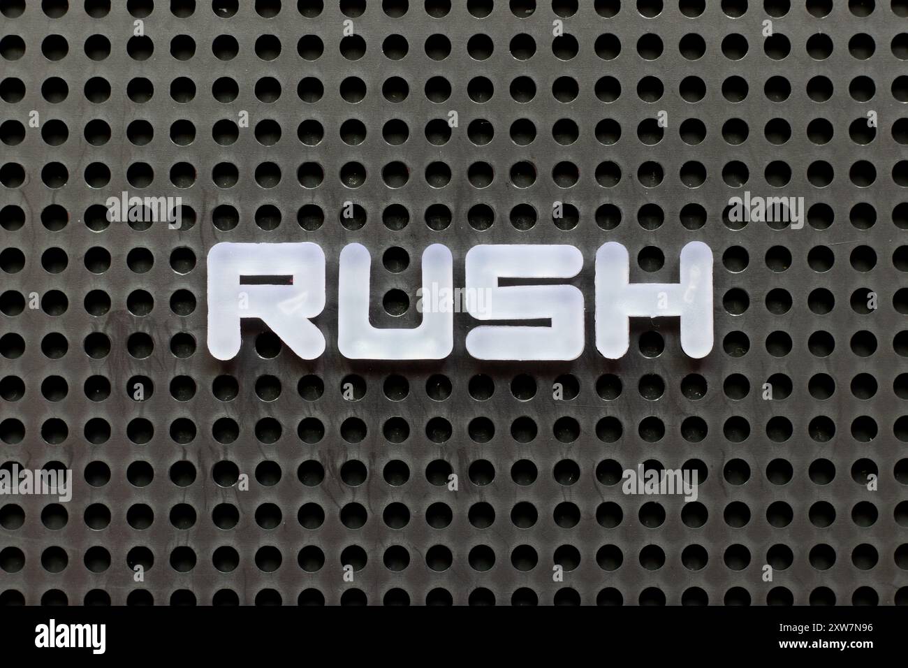 White color letter in word rush on black pegboard background Stock ...