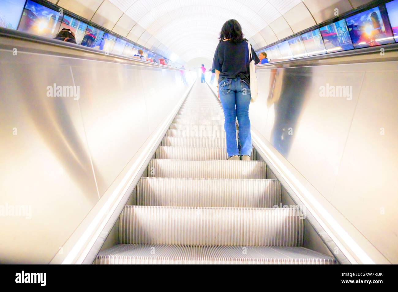 London, UK. Young woman on the up escalatore in Bond Street underground ...