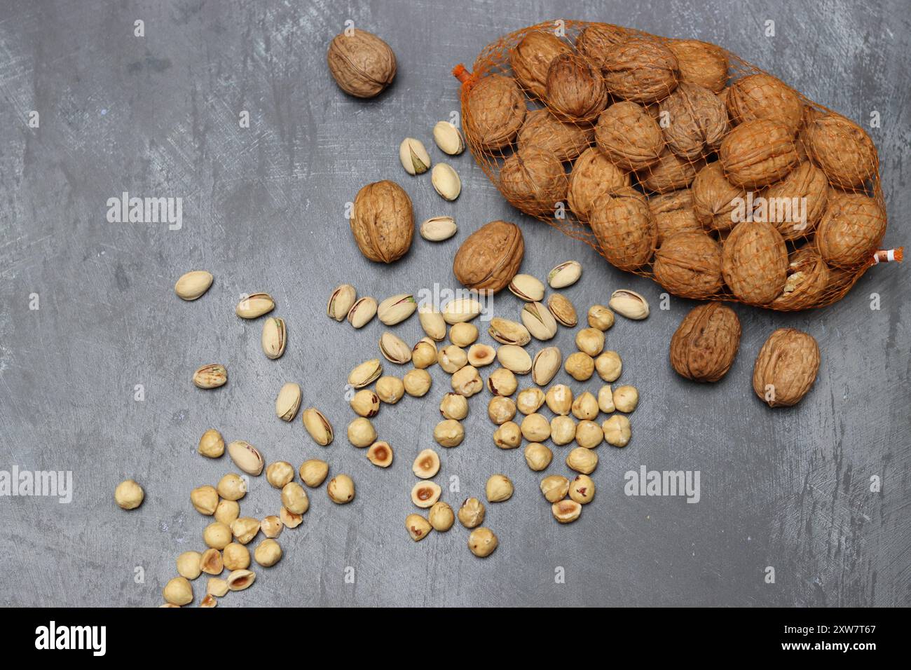 Different types of nuts on a table. Walnut, hazelnut, pistachio on grey ...