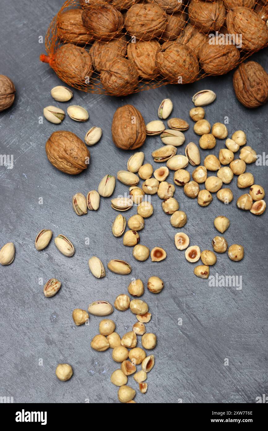 Different types of nuts on a table. Walnut, hazelnut, pistachio on grey ...
