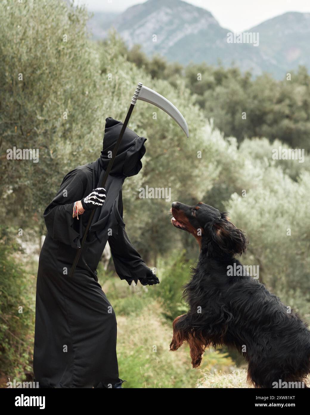 A person dressed as the Grim Reaper in a natural setting is playfully ...