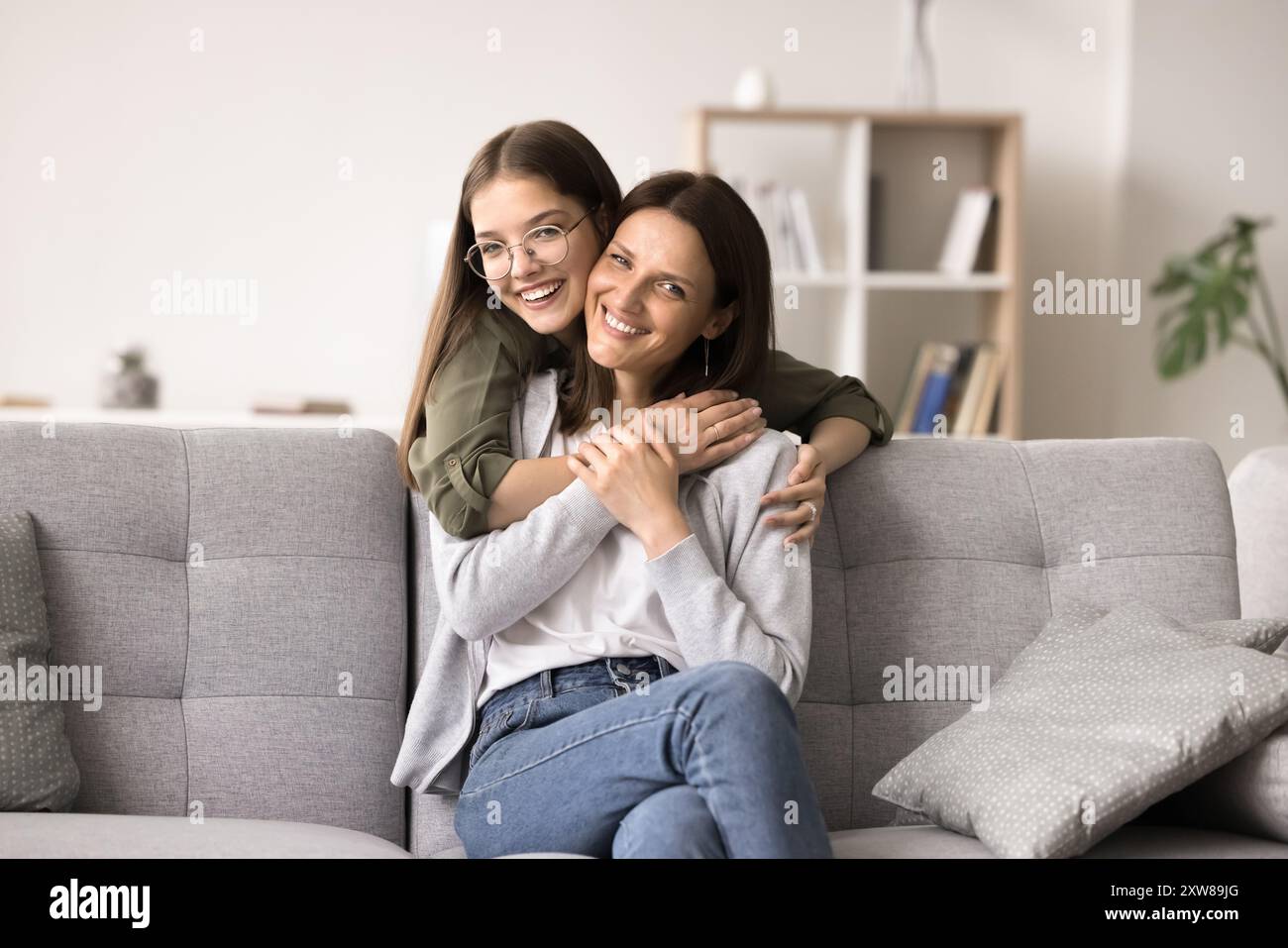 Caring teenage daughter hugging mom from behind Stock Photo - Alamy
