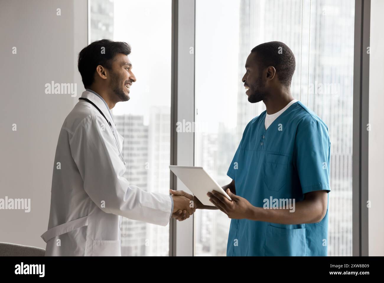 Male chief doctor wear white coat shaking hands African intern Stock ...