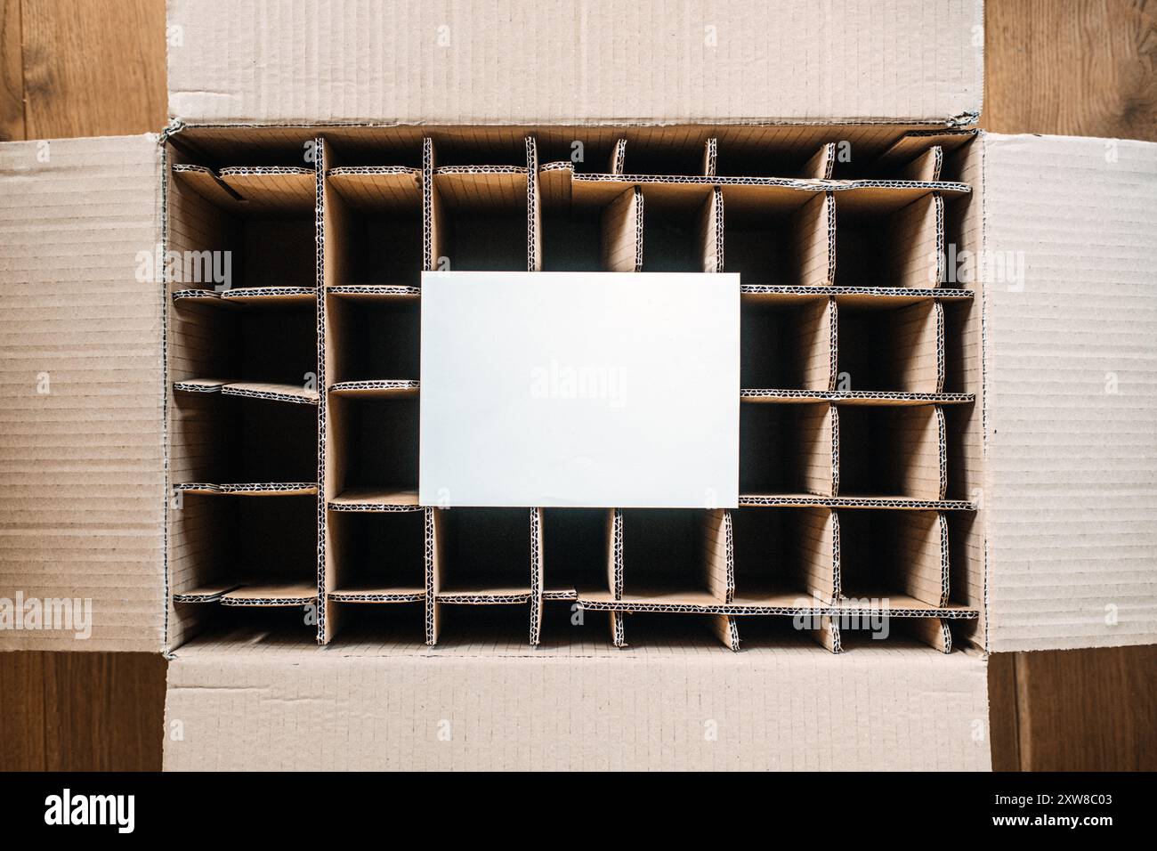 Corrugated cardboard packaging with empty slots and blank white label ...