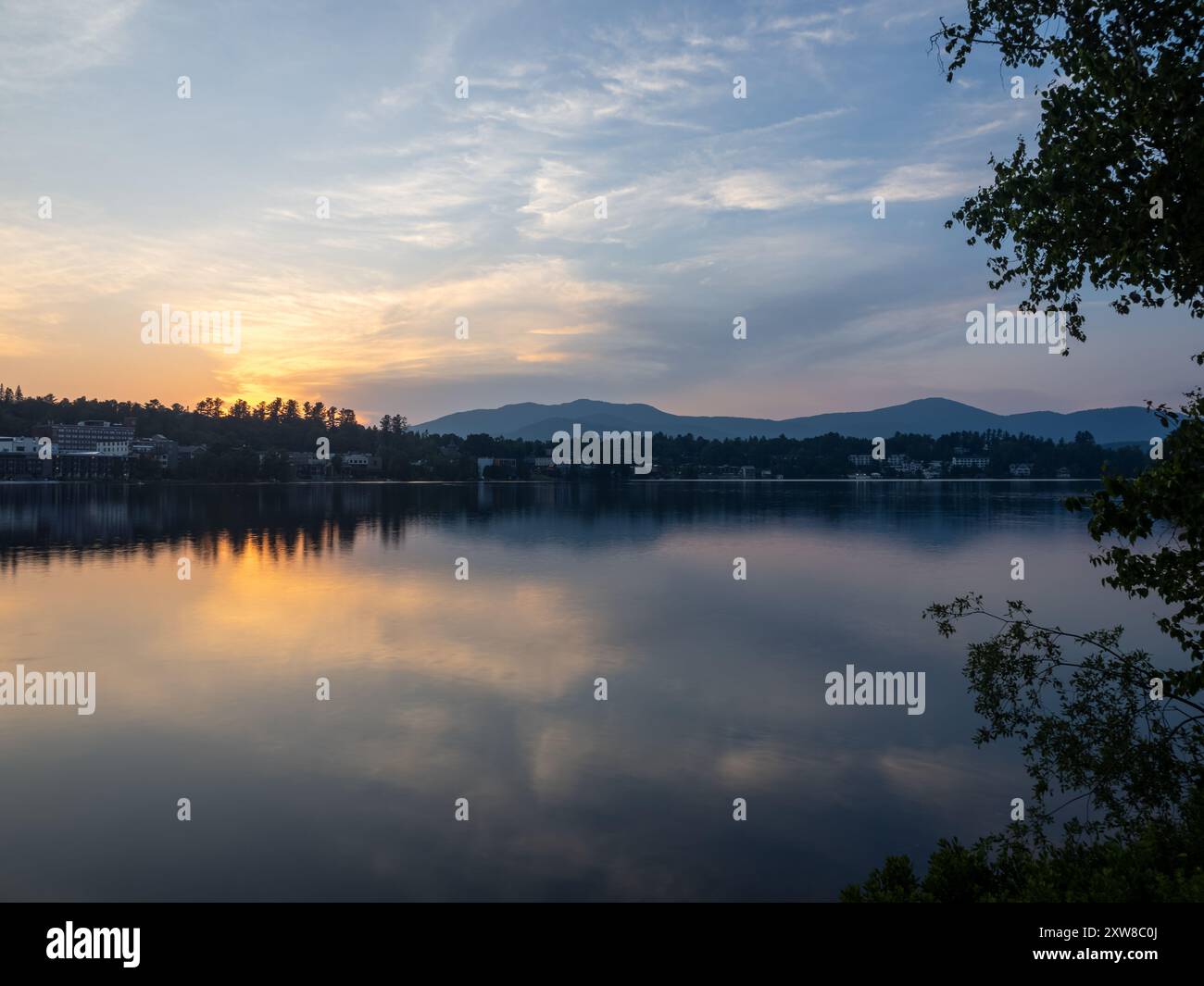 A breathtaking sunset casts golden hues over Lake Placid, reflecting ...