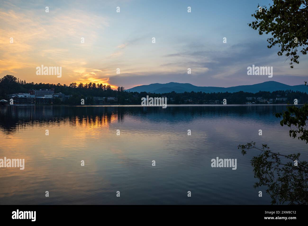 A breathtaking sunset casts golden hues over Lake Placid, reflecting ...