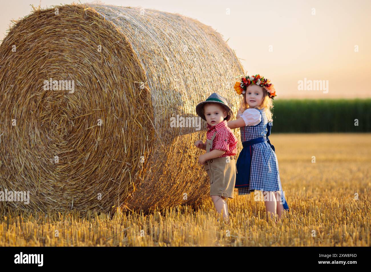 Child in wheat field with bread and pretzel. Oktoberfest time in ...