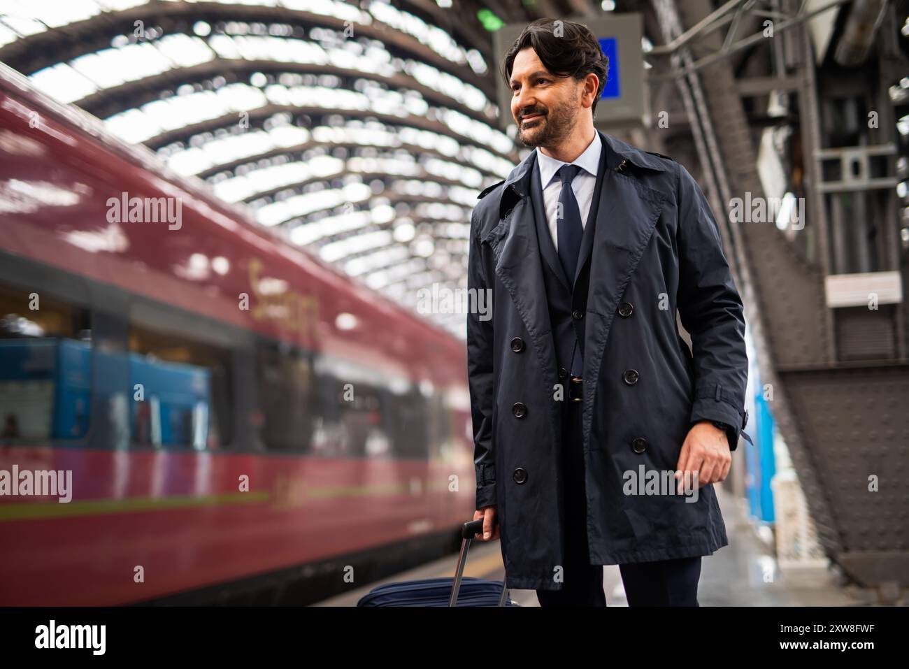 Man taking the train at the railroad station Stock Photo - Alamy