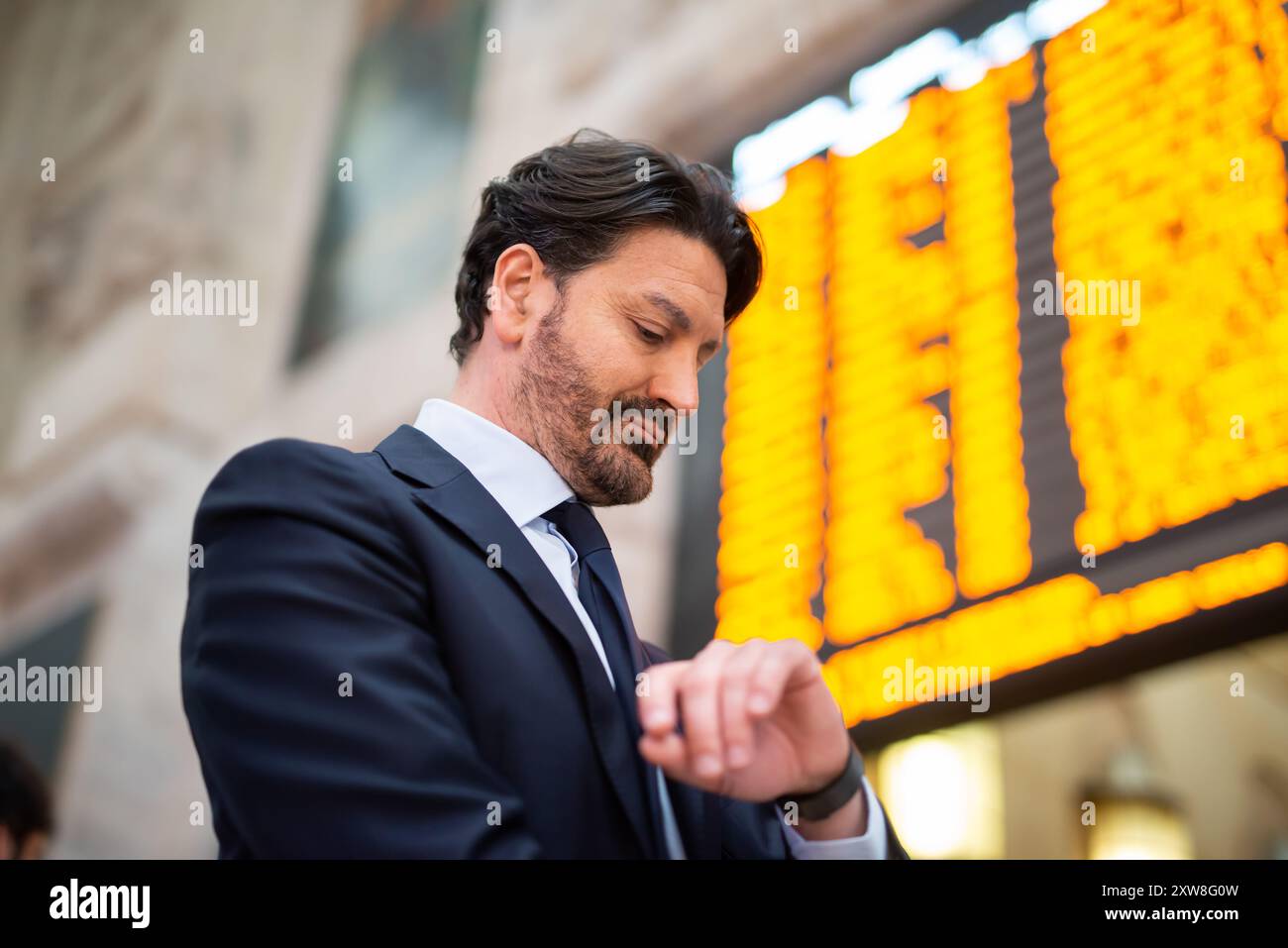 Commuter checking time in front of a timetable Stock Photo - Alamy