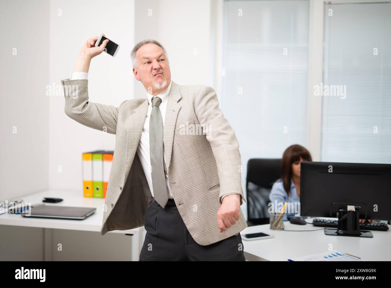 Angry businessman throwing away his phone in the office Stock Photo - Alamy