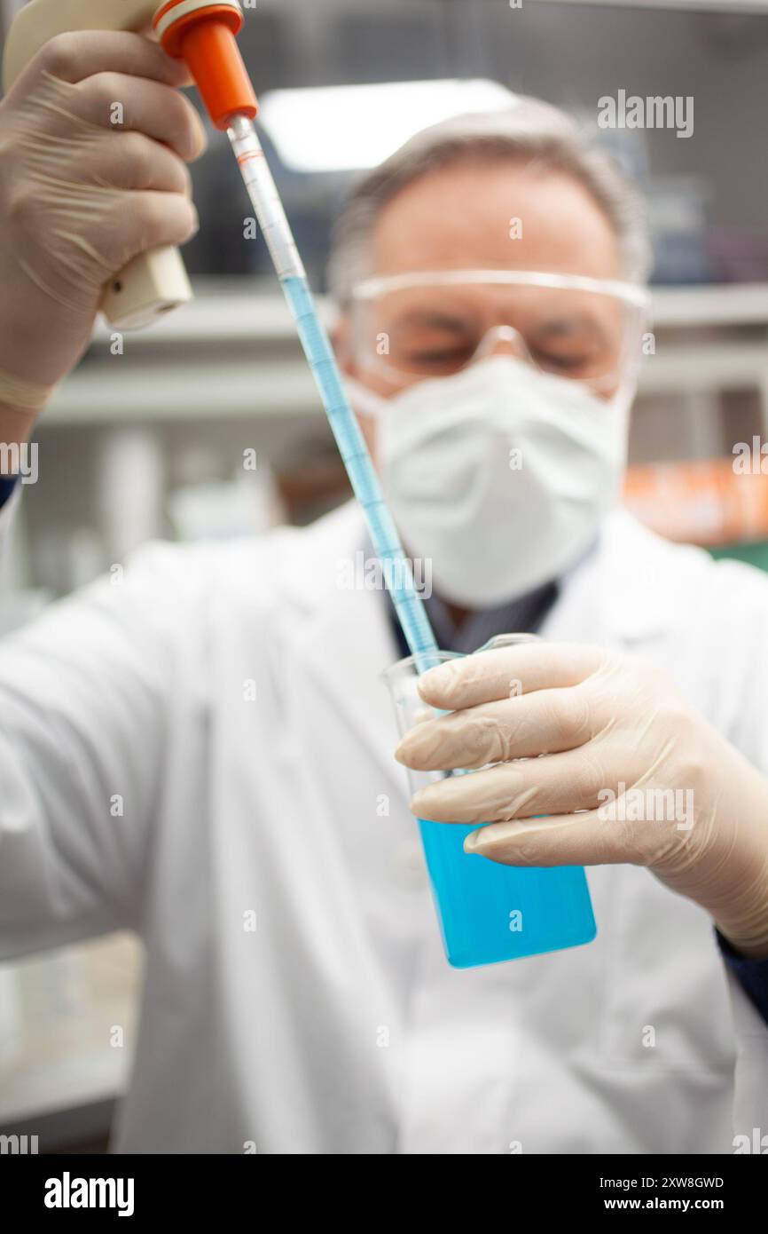 Scientist filling a flask in a chemical laboratory Stock Photo - Alamy