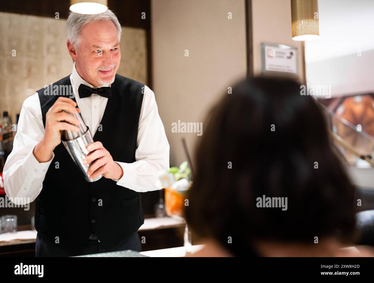 Mature waiter serving cocktails to a couple in a luxury hotel Stock ...