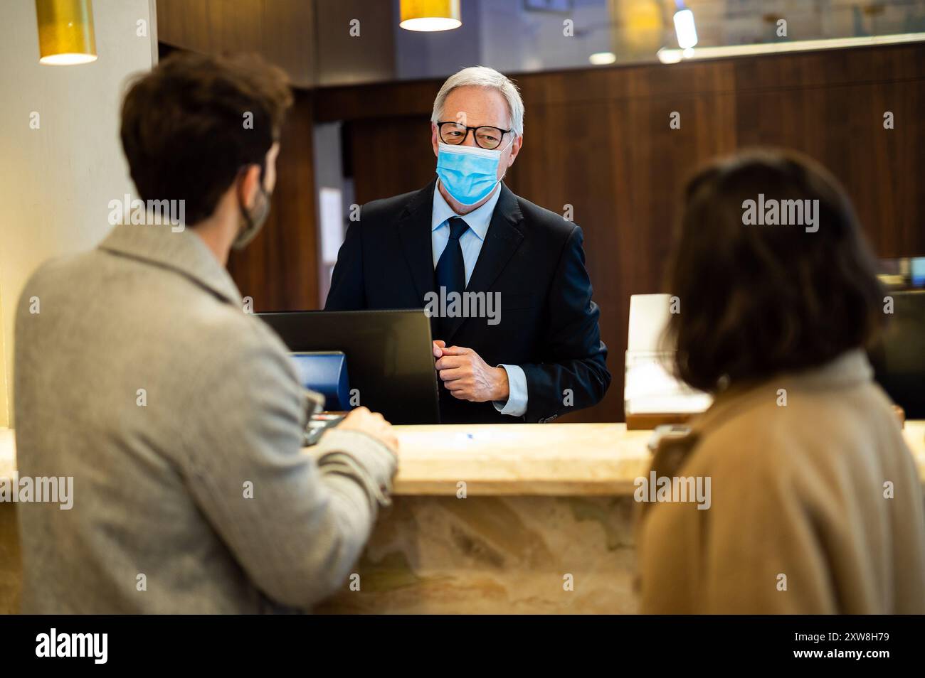 Customers checking in at a hotel reception Stock Photo - Alamy