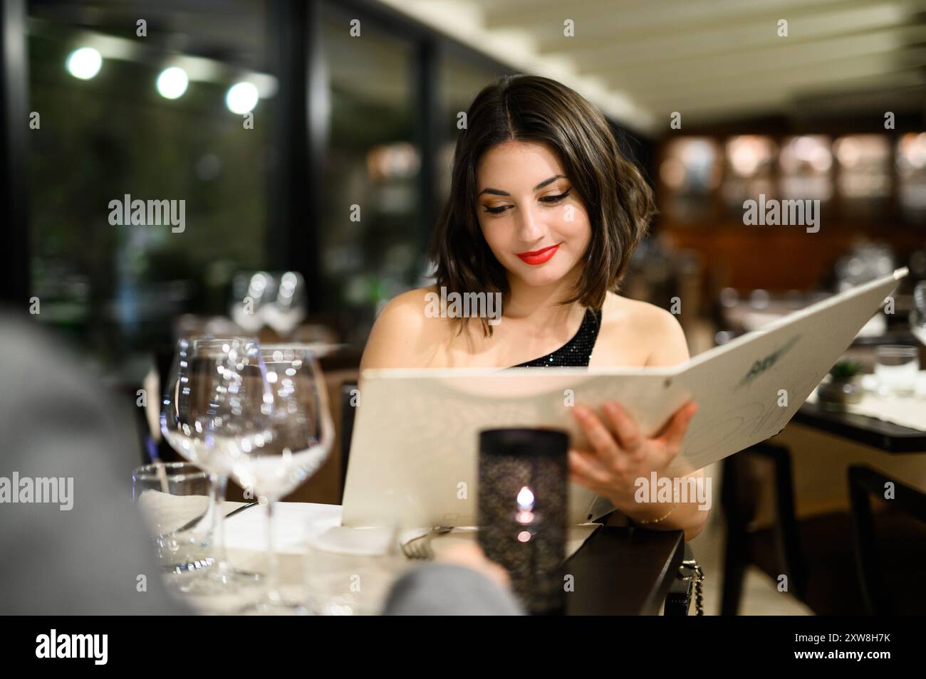 Woman reading the menu at the restaurant Stock Photo - Alamy