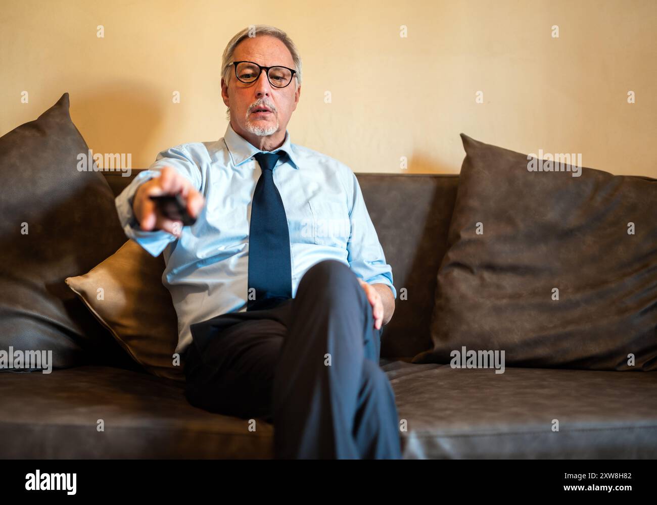 Portrait of a man watching TV on his sofa Stock Photo - Alamy