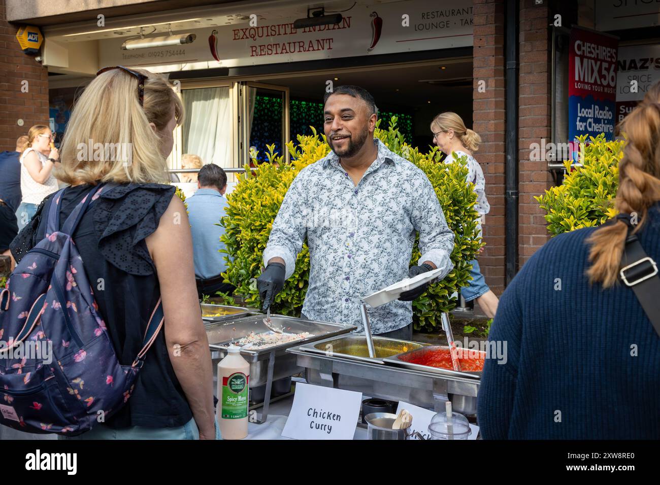Indian man serving curry in the street at the Lymm Food Festival 2024 ...