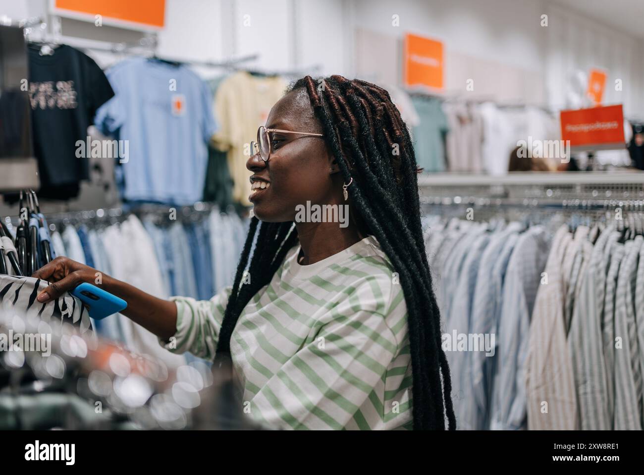 Woman browsing through clothes racks hi-res stock photography and ...