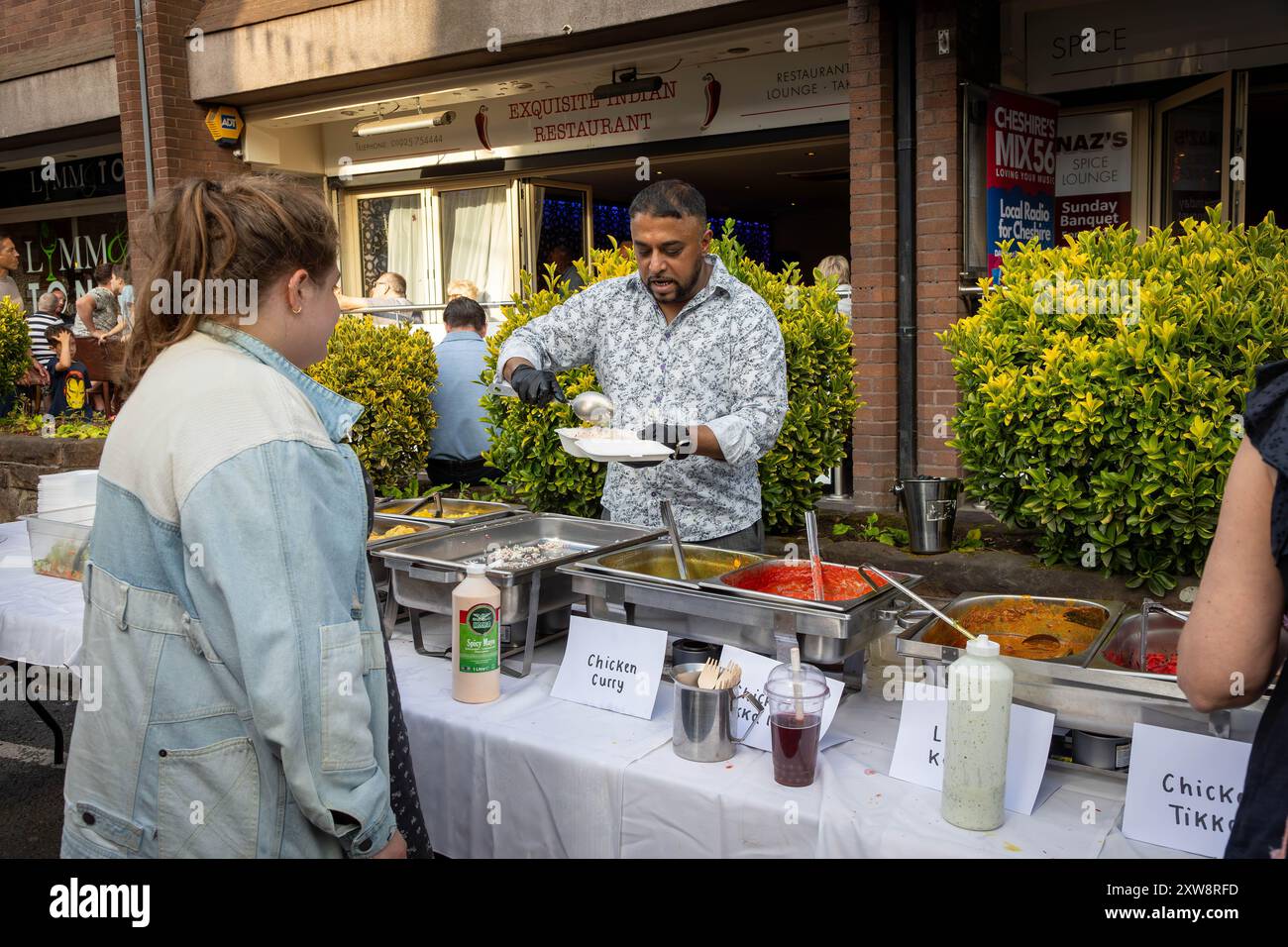 Indian man serving curry in the street at the Lymm Food Festival 2024 ...