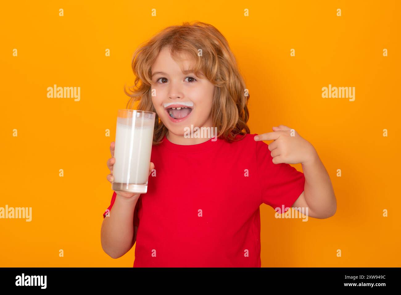 Kid with glass of milk, isolated on yellow studio background Stock ...