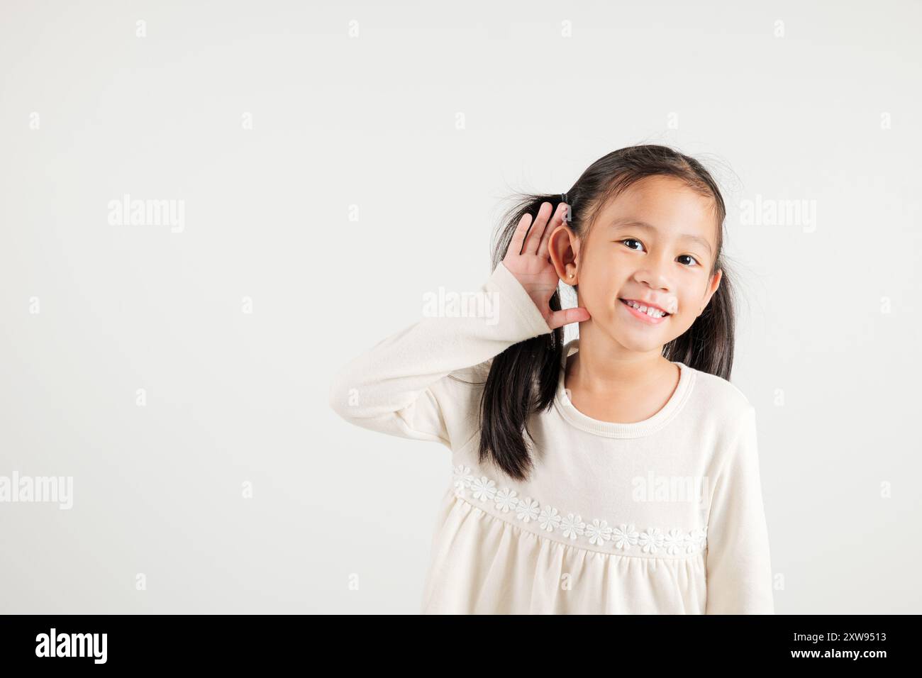 Portrait Asian young child smiling overhearing listening sound to ...