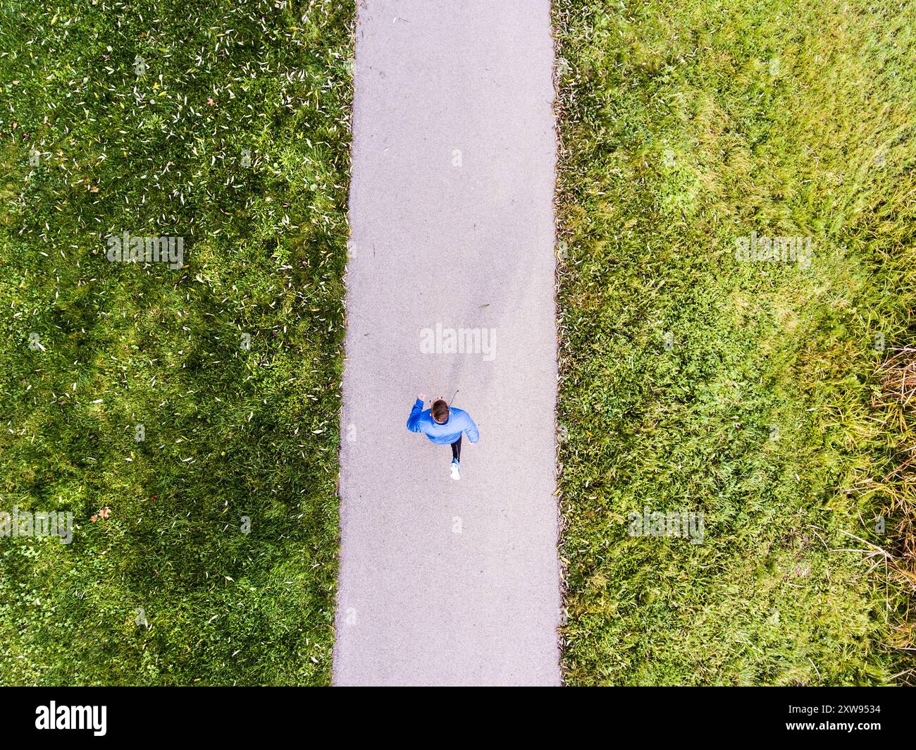 Aerial view of a runner running through the park on a jogging path ...