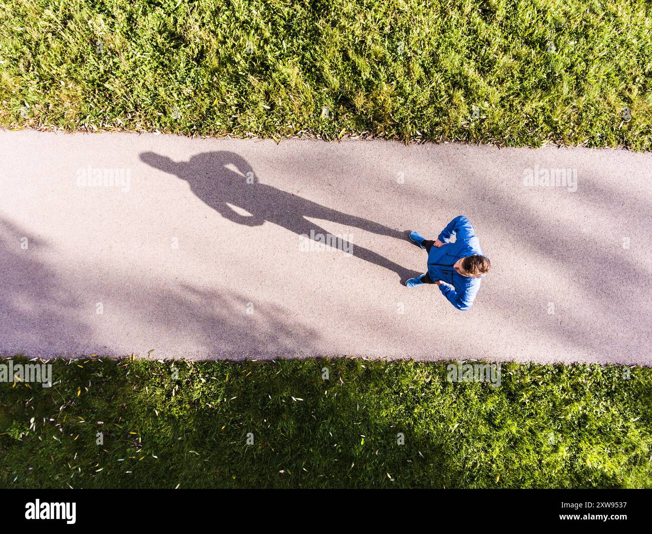 Aerial view of a runner running through the park on a jogging path ...