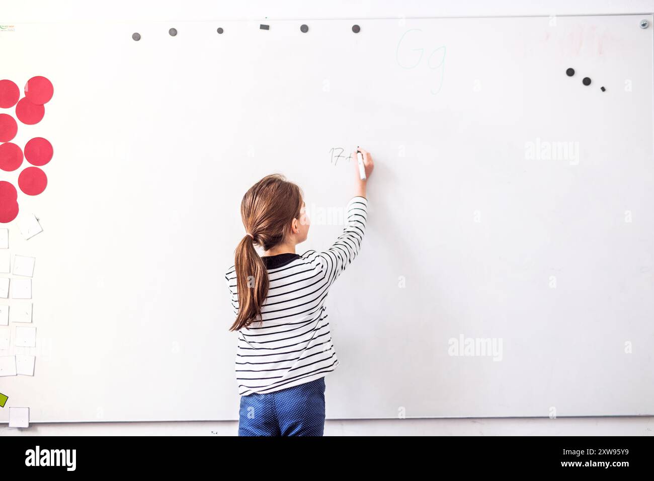 Girl student writing on whiteboard in classroom Stock Photo - Alamy