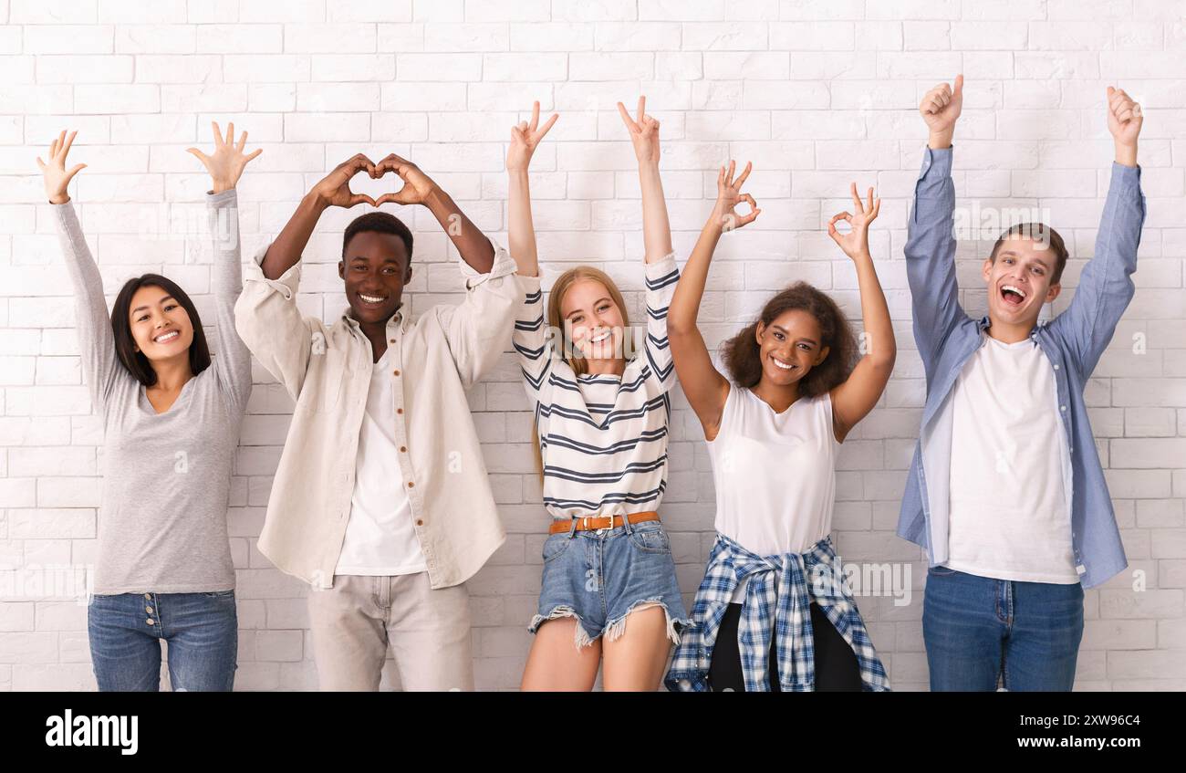 Lifeful young friends putting hands up, showing diverse gestures Stock ...