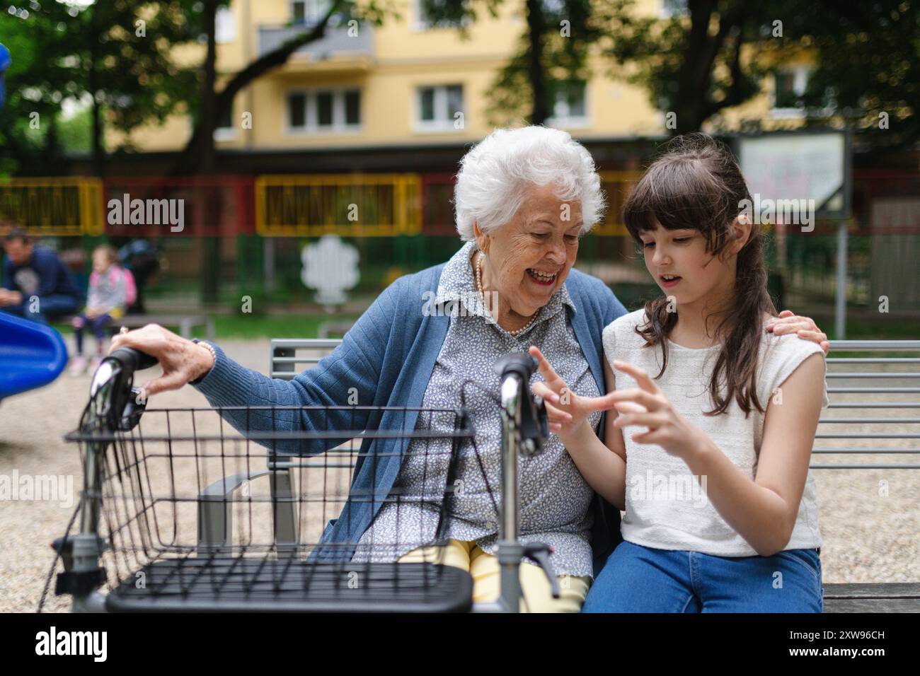 Grandma with walker picking up young girl from school at afternoon ...