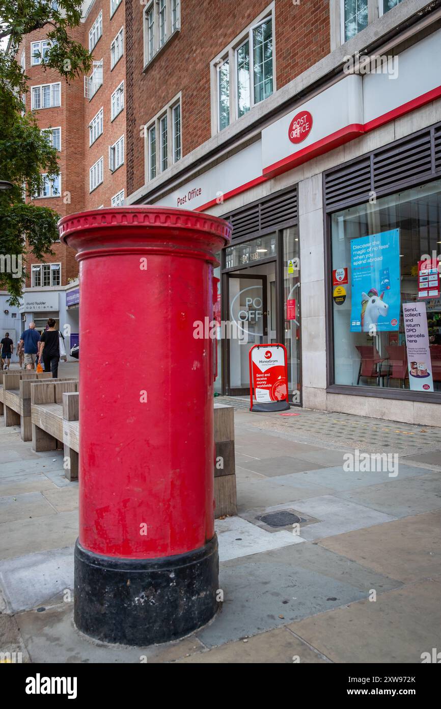 Branch of the Post Office with red pillar mail box in front Stock Photo ...